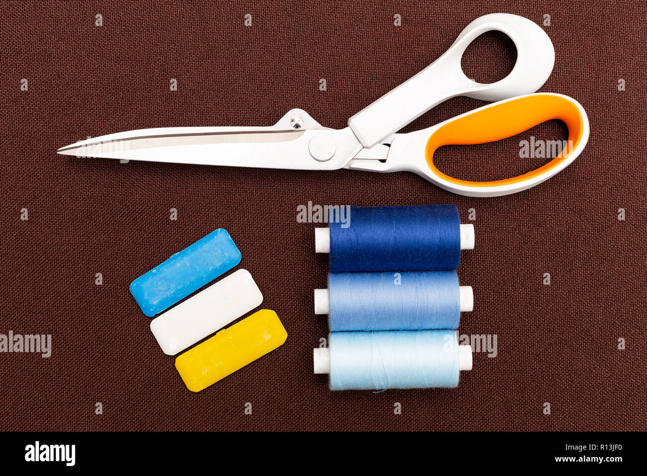 Sewing equipment as pair of scissors, spools of thread and coloured ...