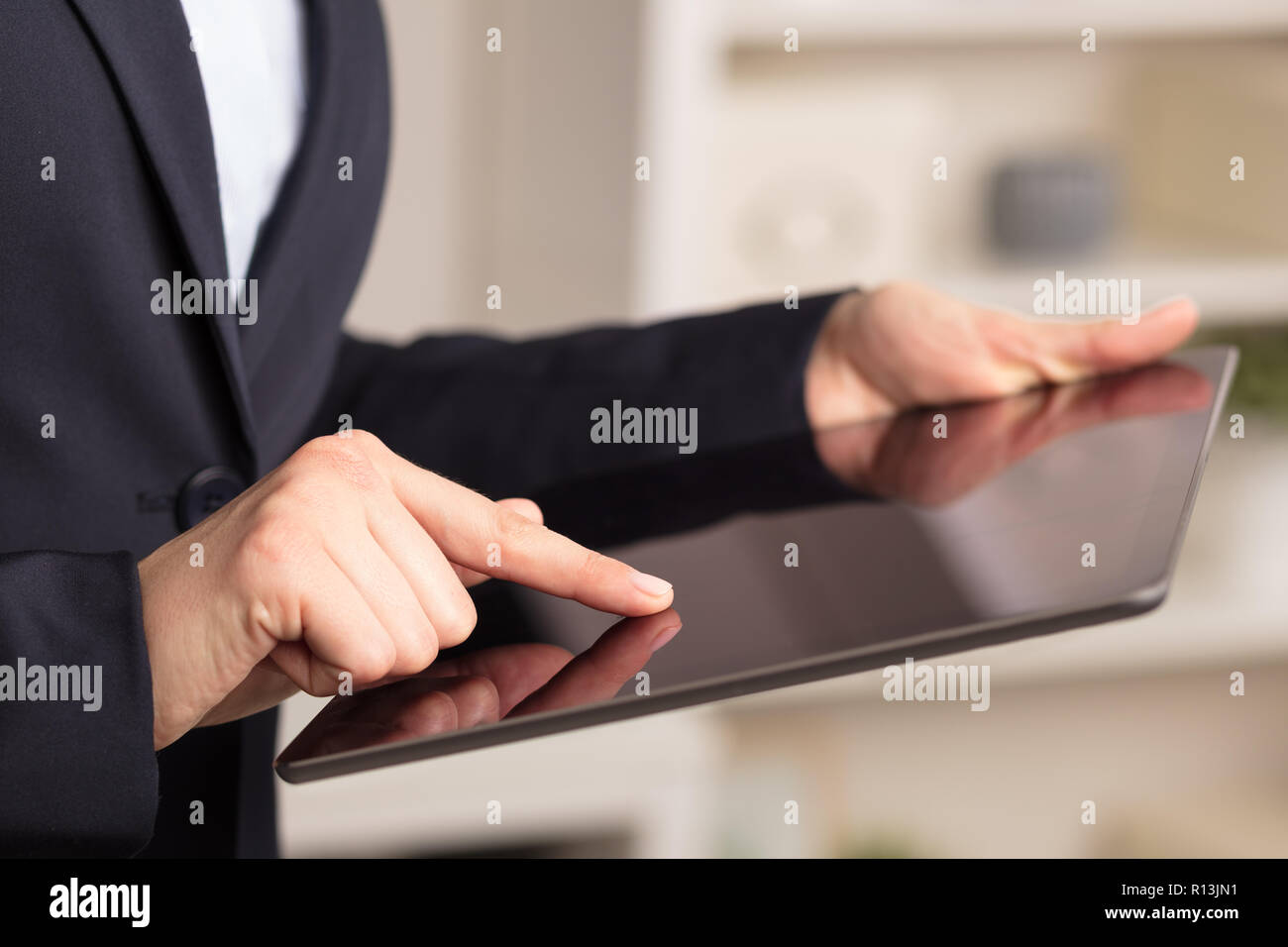 Business woman below chest using tablet in a homey environment Stock ...
