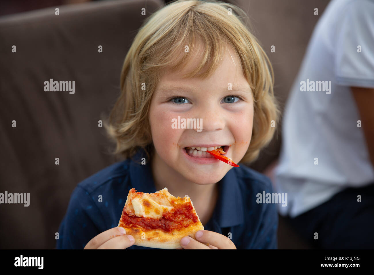 The cute boy is eating pizza in an Italian restaurant Stock Photo - Alamy