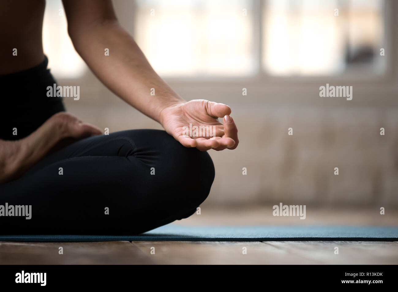 Sporty yogi woman practicing yoga, doing Ardha Padmasana exercis Stock ...