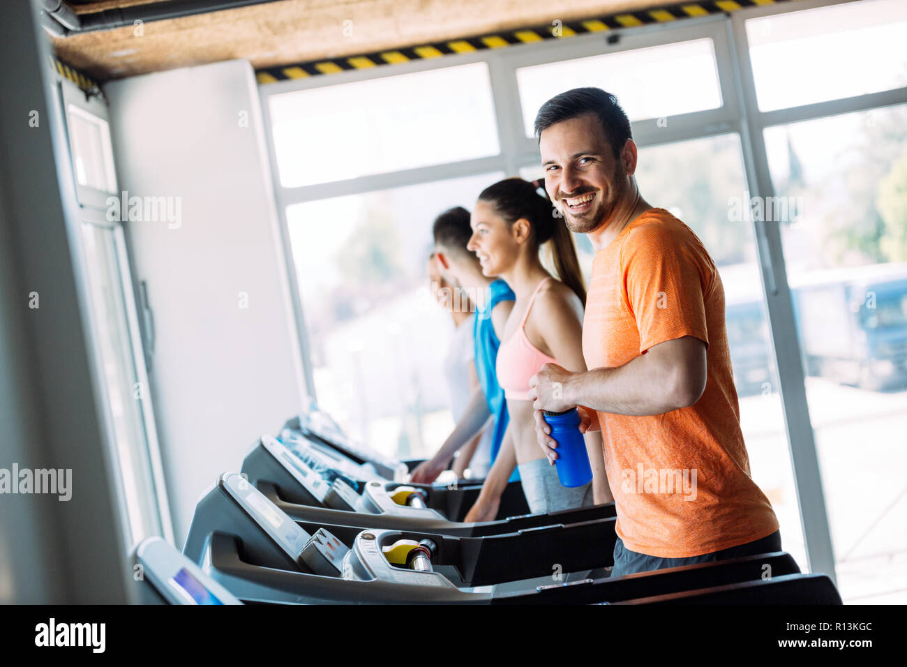 Happy people on treadmills in the gym Stock Photo - Alamy