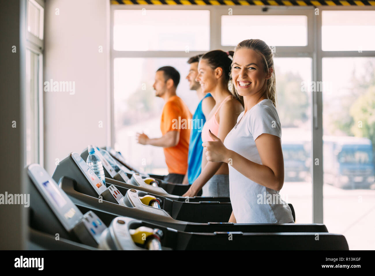 Healthy man and woman running on a treadmill in a gym Stock Photo - Alamy