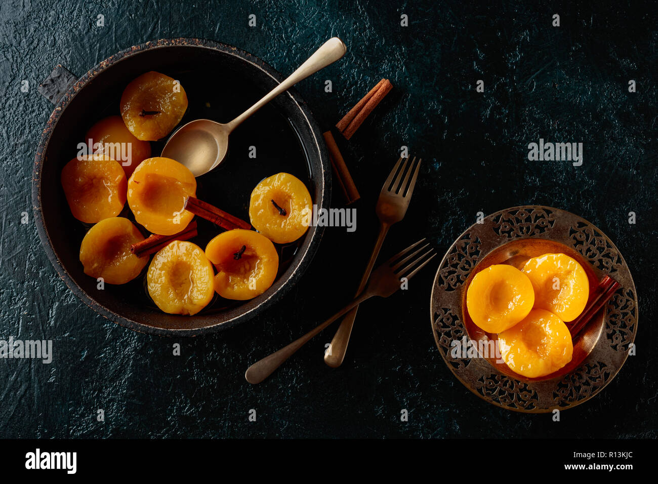 Peach dessert with cinnamon and cloves on a dark background, top view ...