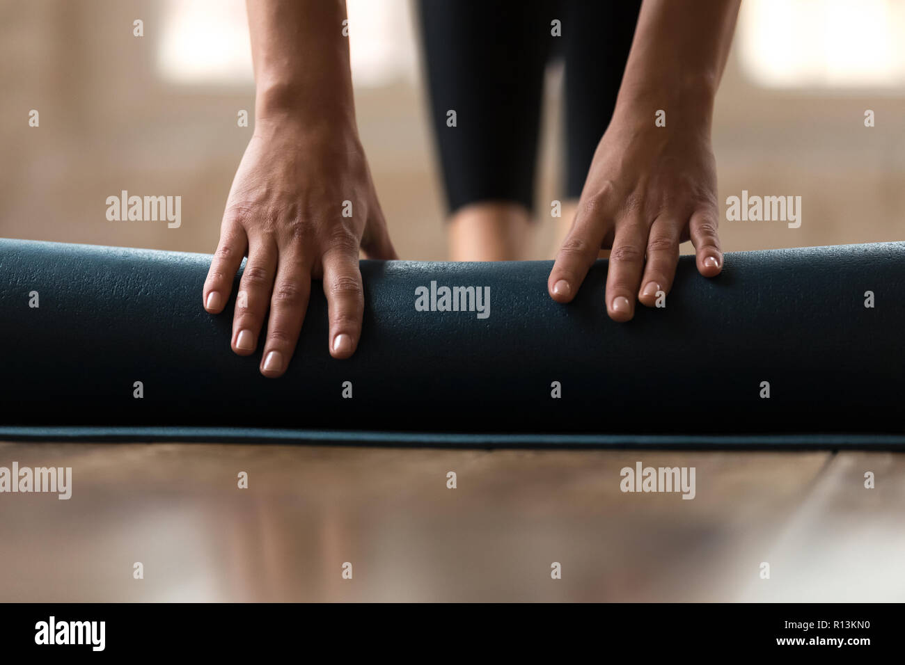 Front view of female hands folding blue exercise mat Stock Photo - Alamy