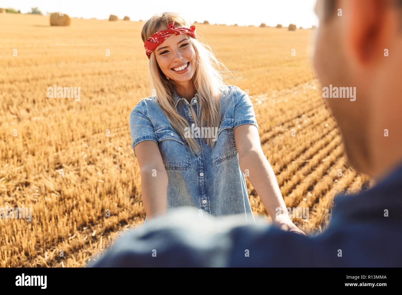 Photo of happy young cute loving couple standing on the field walking ...