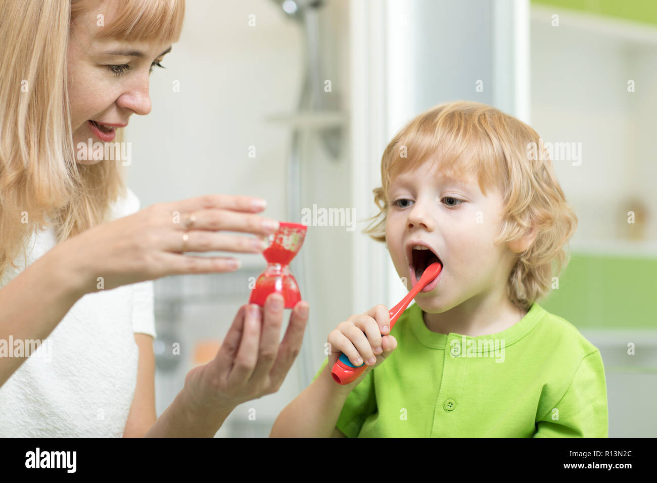 Child toddler brushing his teeth with mother in the bathroom Stock ...
