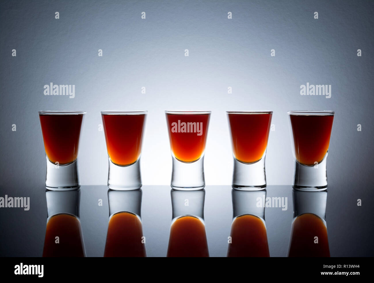 small glasses with a drink shots of alcohol stainding in a table with ...