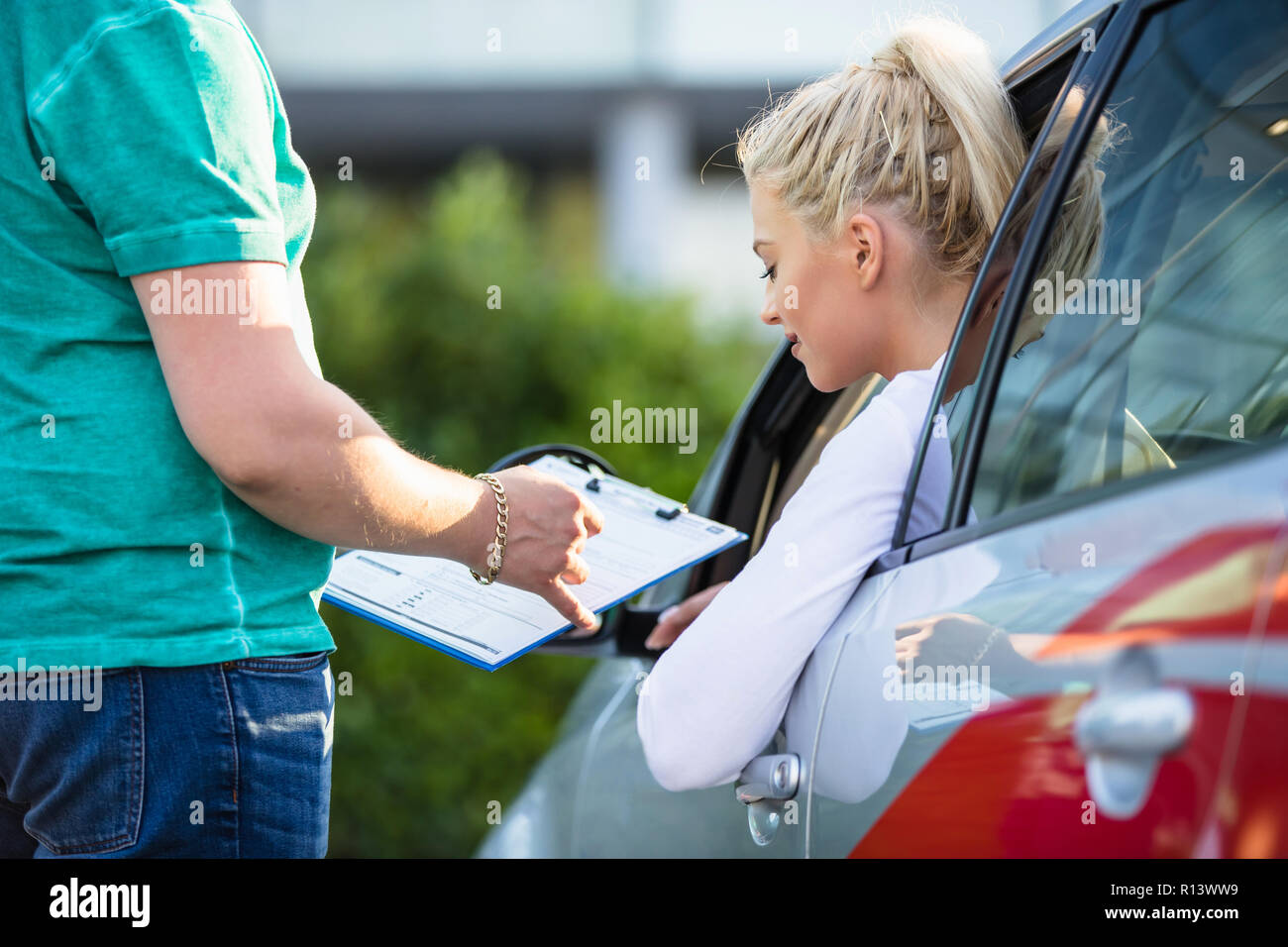 Driving school. Young woman on a driving test with her instructor ...