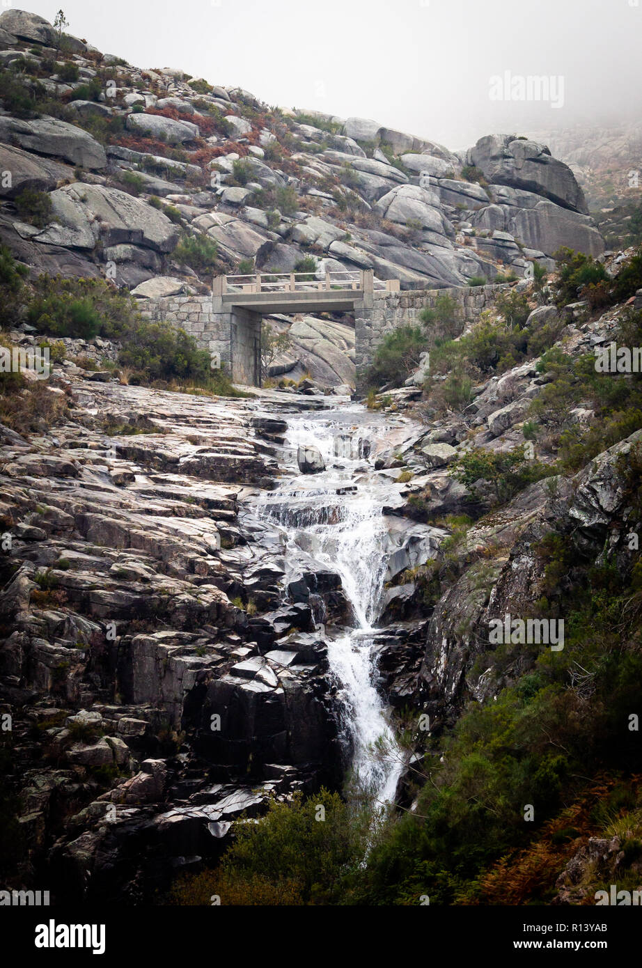 Waterfall below stone bridge. Rocky landscape Stock Photo - Alamy