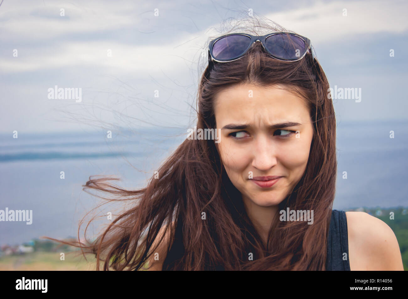 A women with a funny expression because fluttering hair tickle face ...