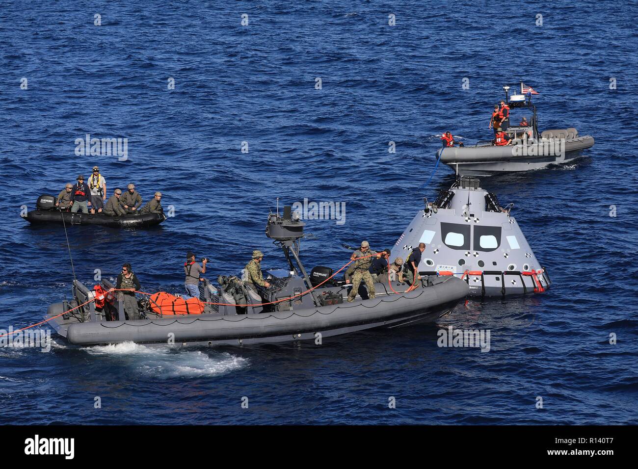 NASA recovery team and U.S. Navy divers secure a mock up version of the ...