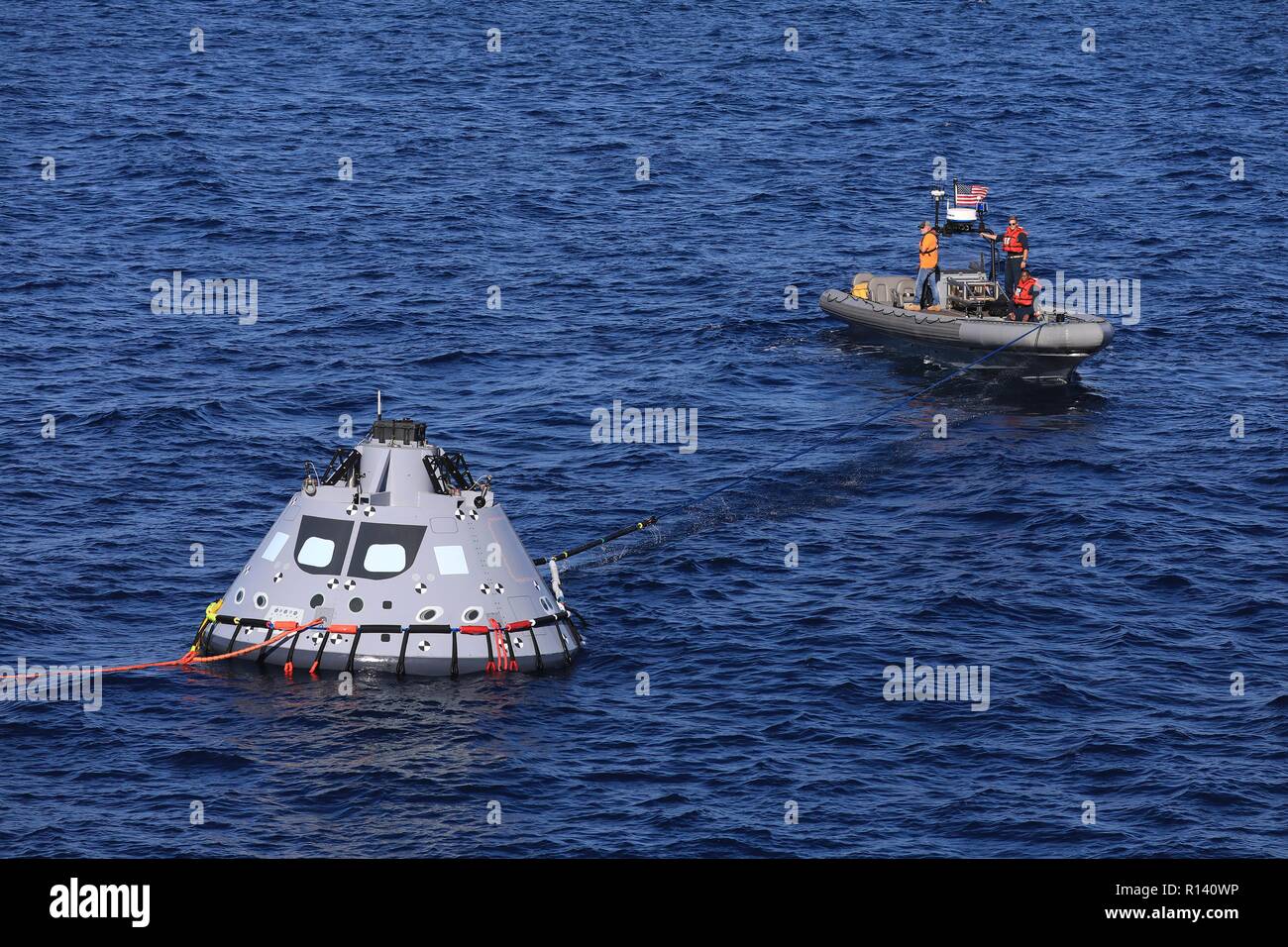 NASA recovery team and U.S. Navy divers tow a mock up version of the ...