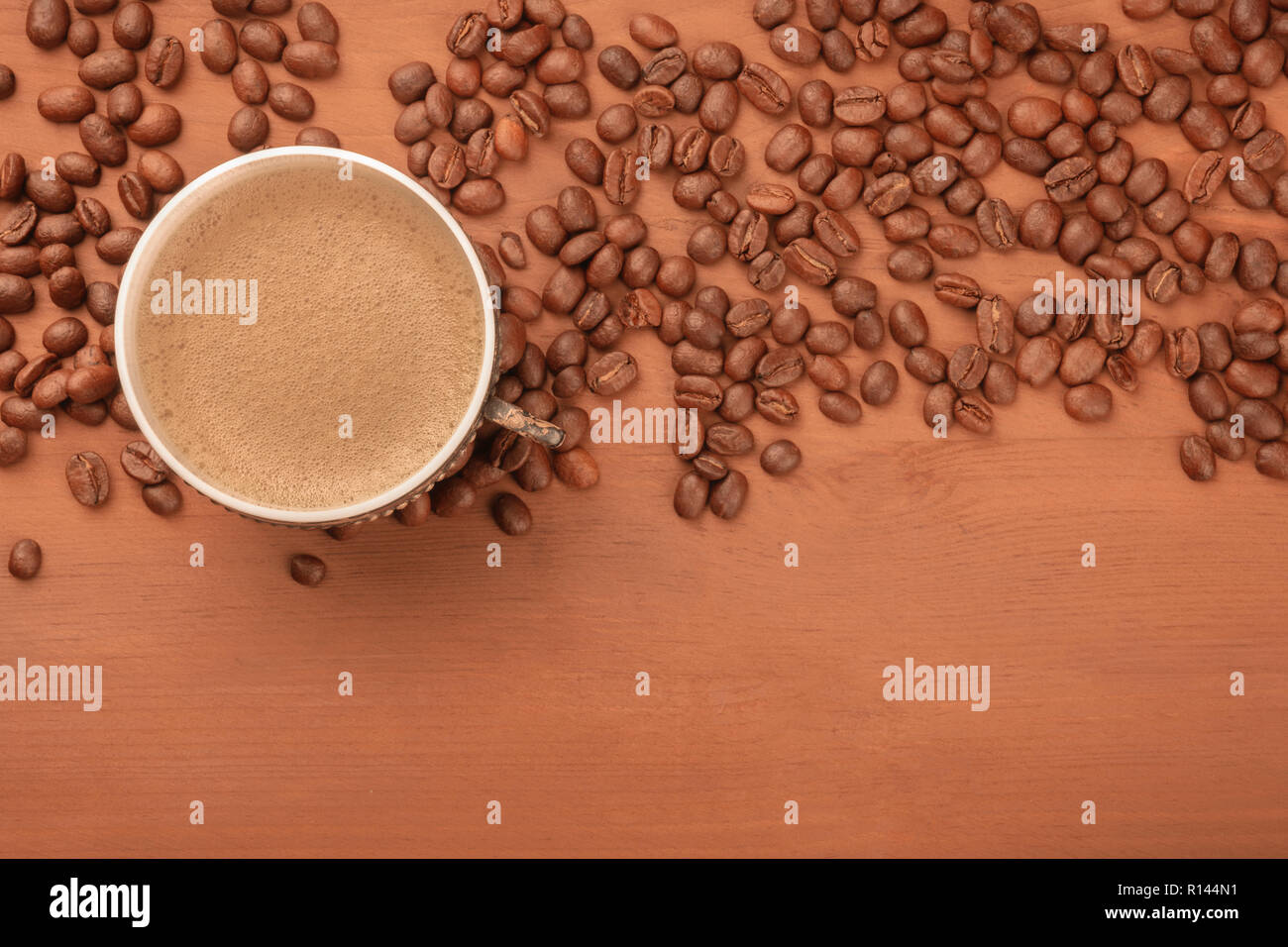 An overhead photo of coffee in a vintage cup, with roasted coffee beans ...
