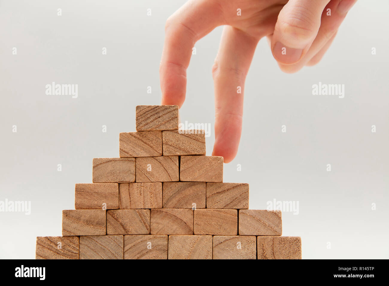Persons hand walking up a set of wooden blocks. Business development ...