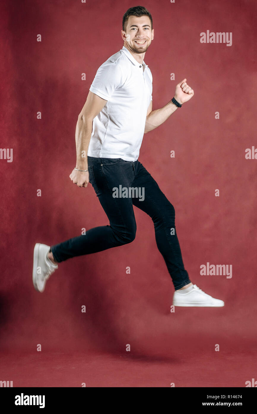 Jumping man happy excited. Funny portrait on a young casual male male ...