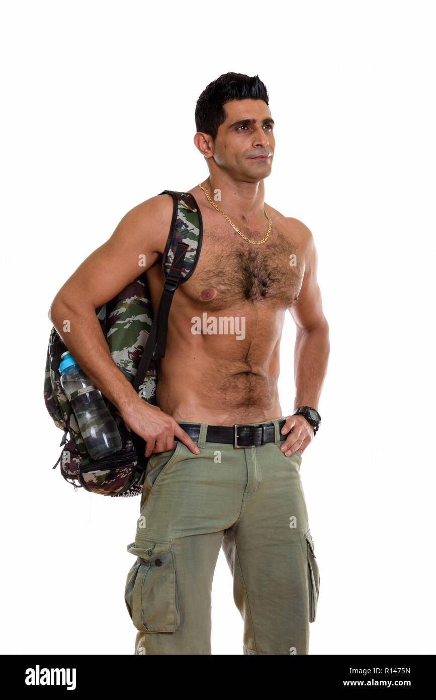 Studio shot of young muscular Persian man standing and thinking Stock ...
