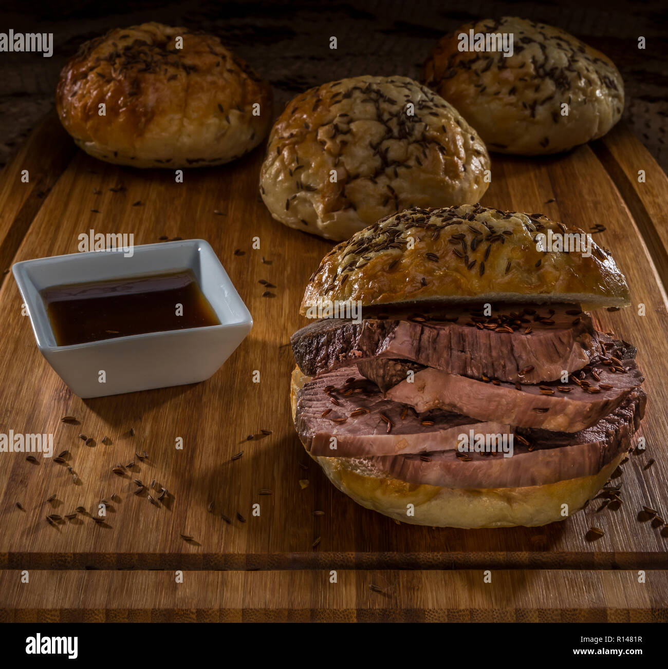 roastbeef on kimmelweck roll on wooden cutting board with au jus Stock ...