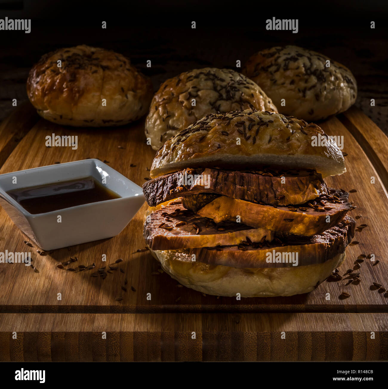 roastbeef on kimmelweck roll on wooden cutting board with au jus Stock ...