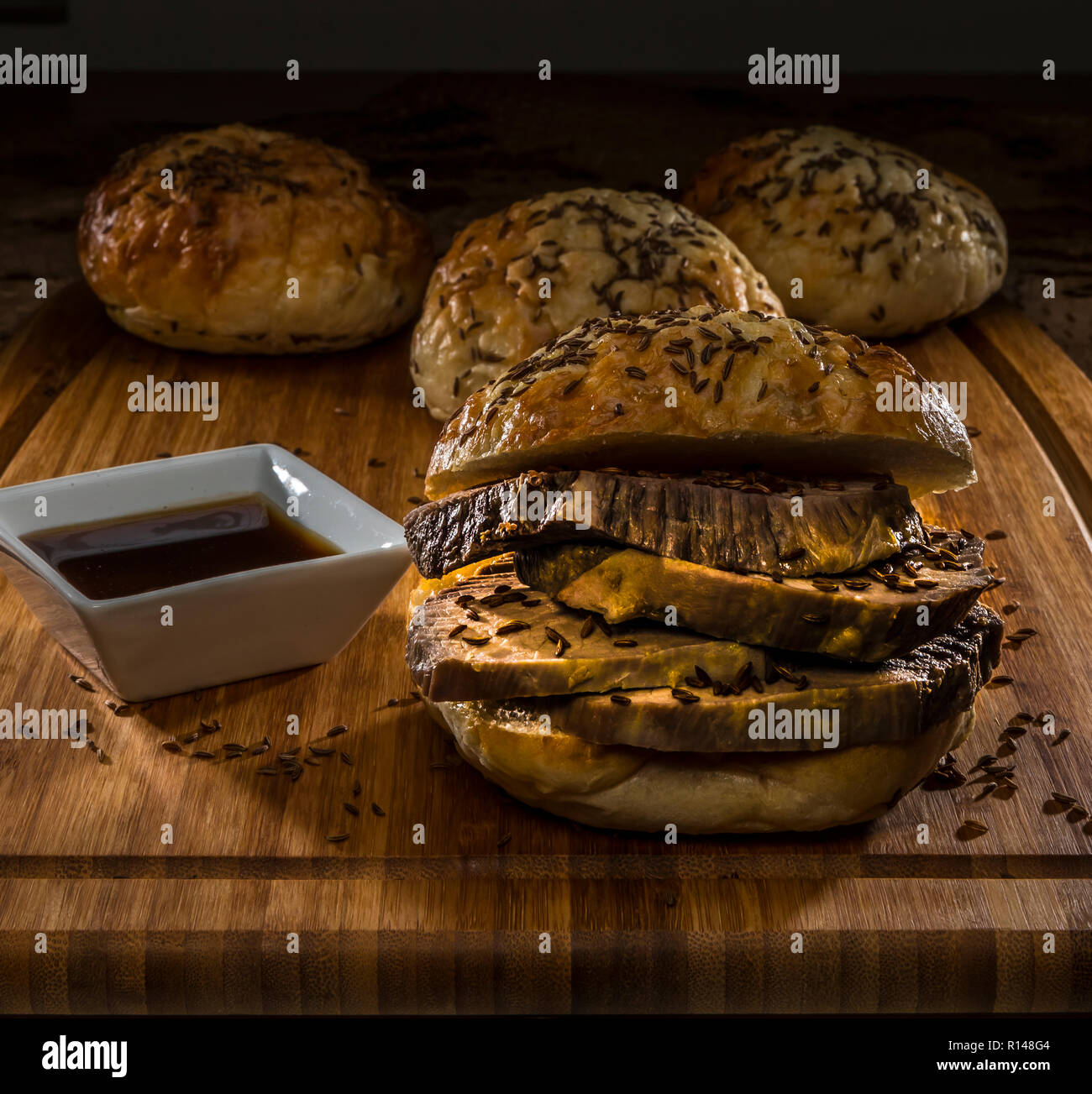 roastbeef on kimmelweck roll on wooden cutting board with au jus Stock ...