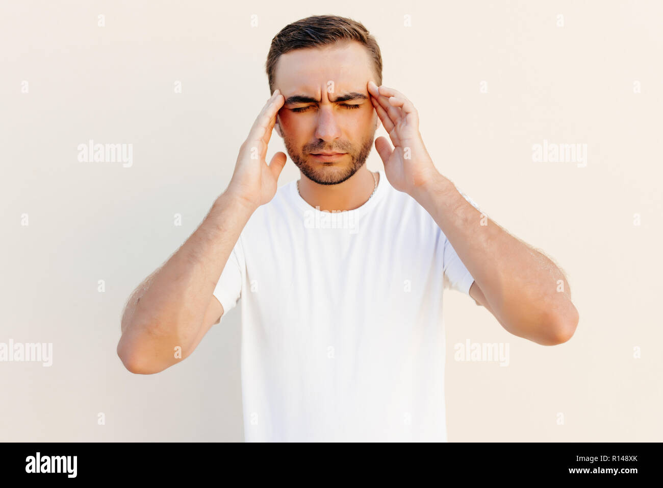 Man having headache Isolated on orange background. Handsome man ...
