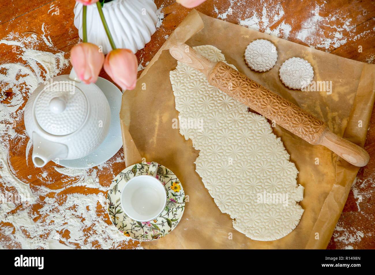 Rolling pin with a pattern on a wooden decorated table covered with ...