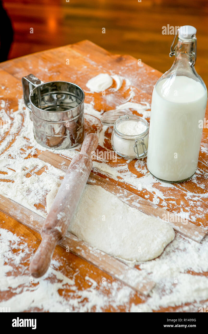 Rolling pin on a wooden decorated table covered with baked flour ...