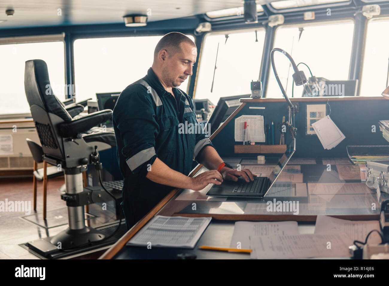 Marine navigational officer is using laptop or notebook at sea Stock ...