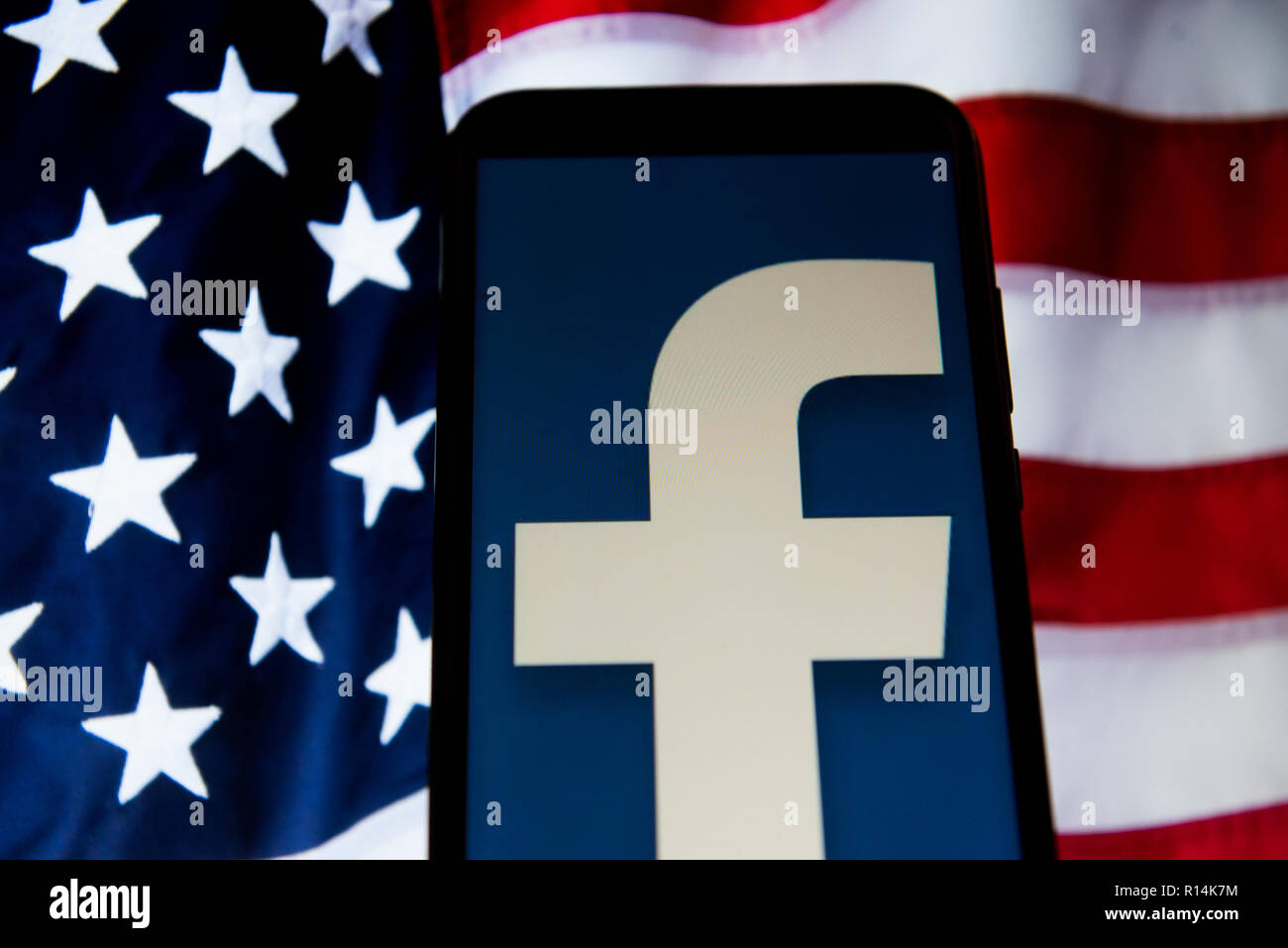 Facebook logo is seen on an Android mobile device with USA flag on the ...
