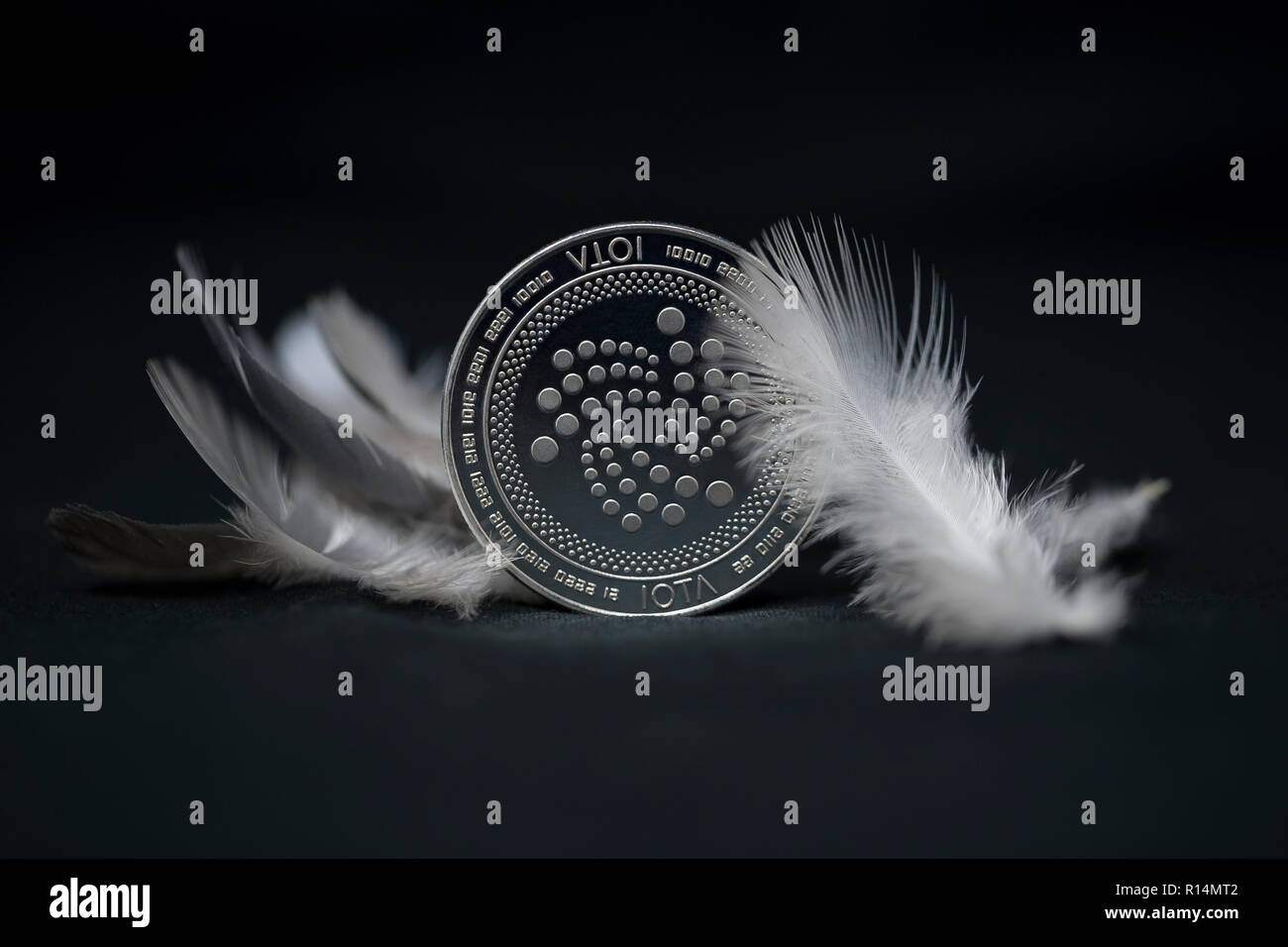 Iota cryptocurrency physical coin surrounded with feathers Stock Photo ...
