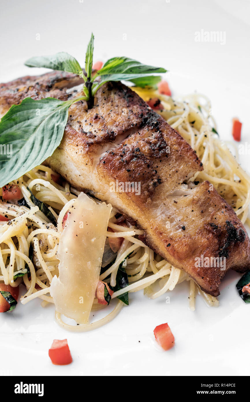 fresh cod fish fillet on mixed vegetable and parmesan spaghetti pasta ...