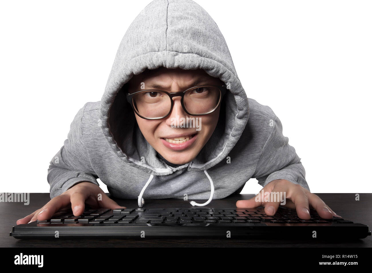 a perturbed programmer with glasses and a hood in front of the keyboard ...