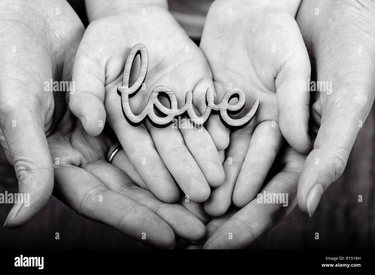concept of family values - hands holding word love Stock Photo - Alamy