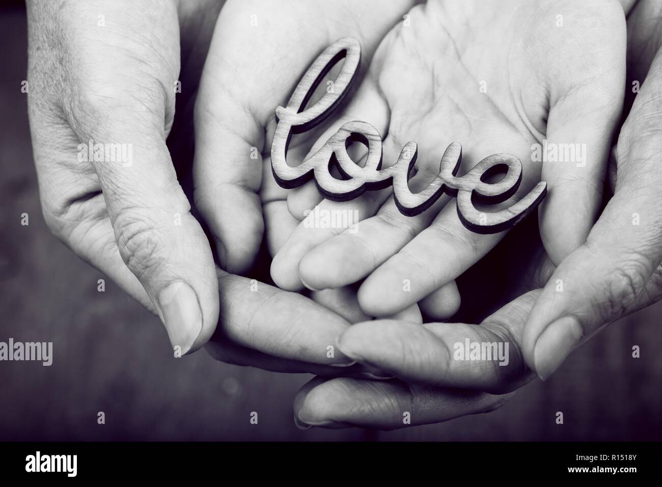 concept of family values - hands holding word love Stock Photo - Alamy