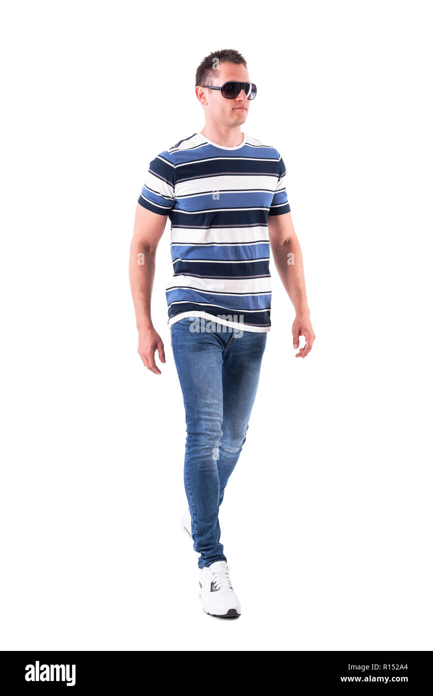 Serious confident male fashion model walking with sunglasses and ...