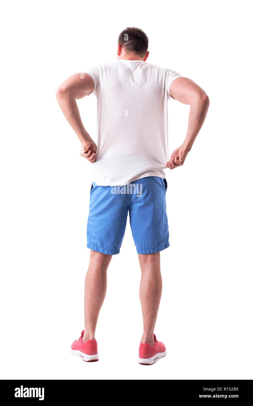 Back view of young handsome man adjusting and putting on summer clothes ...