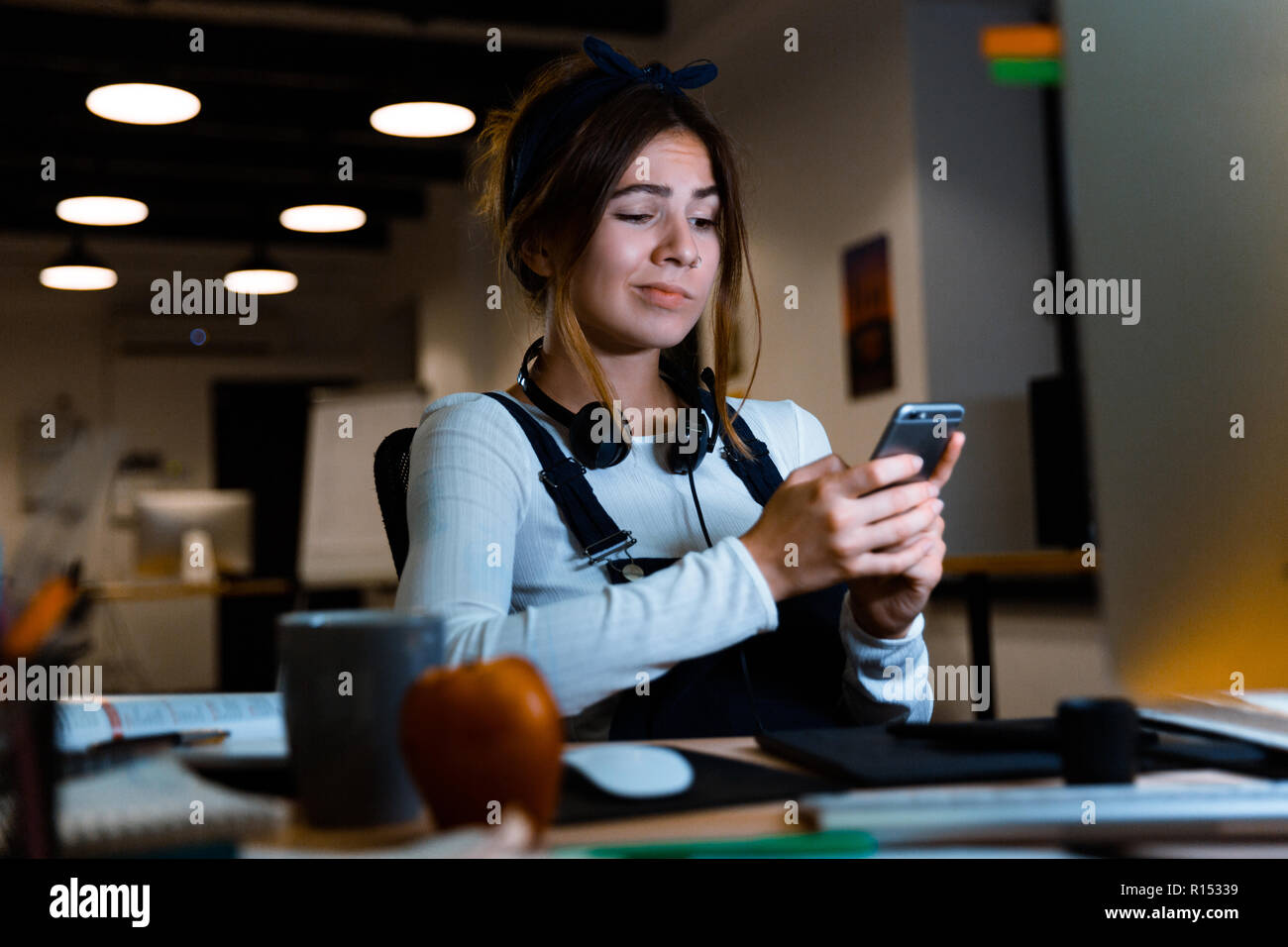 Image of confused young woman designer sitting in office working using ...