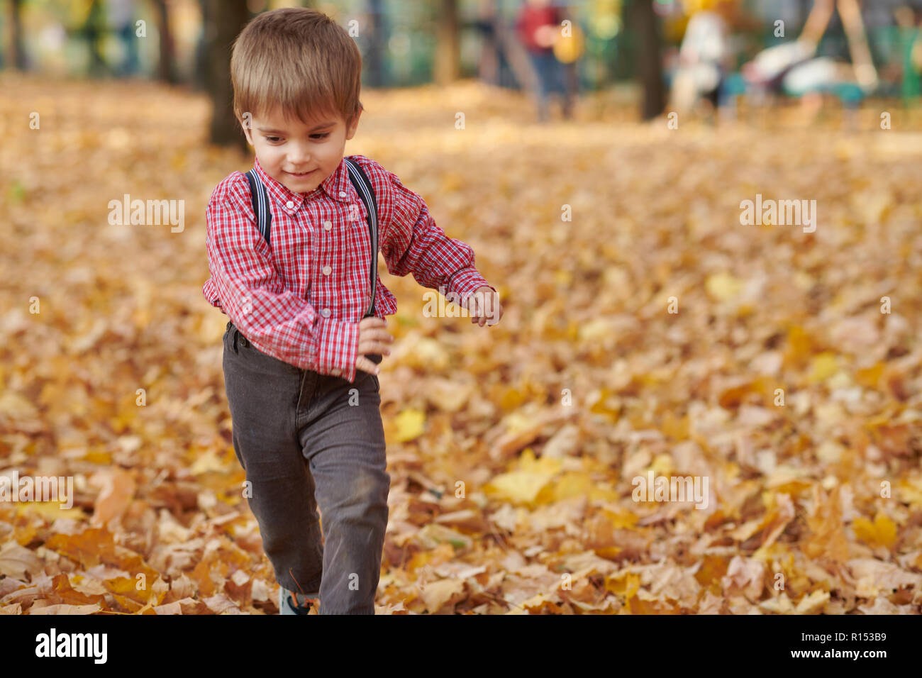 Child boy is running in autumn city park. Bright yellow trees Stock ...