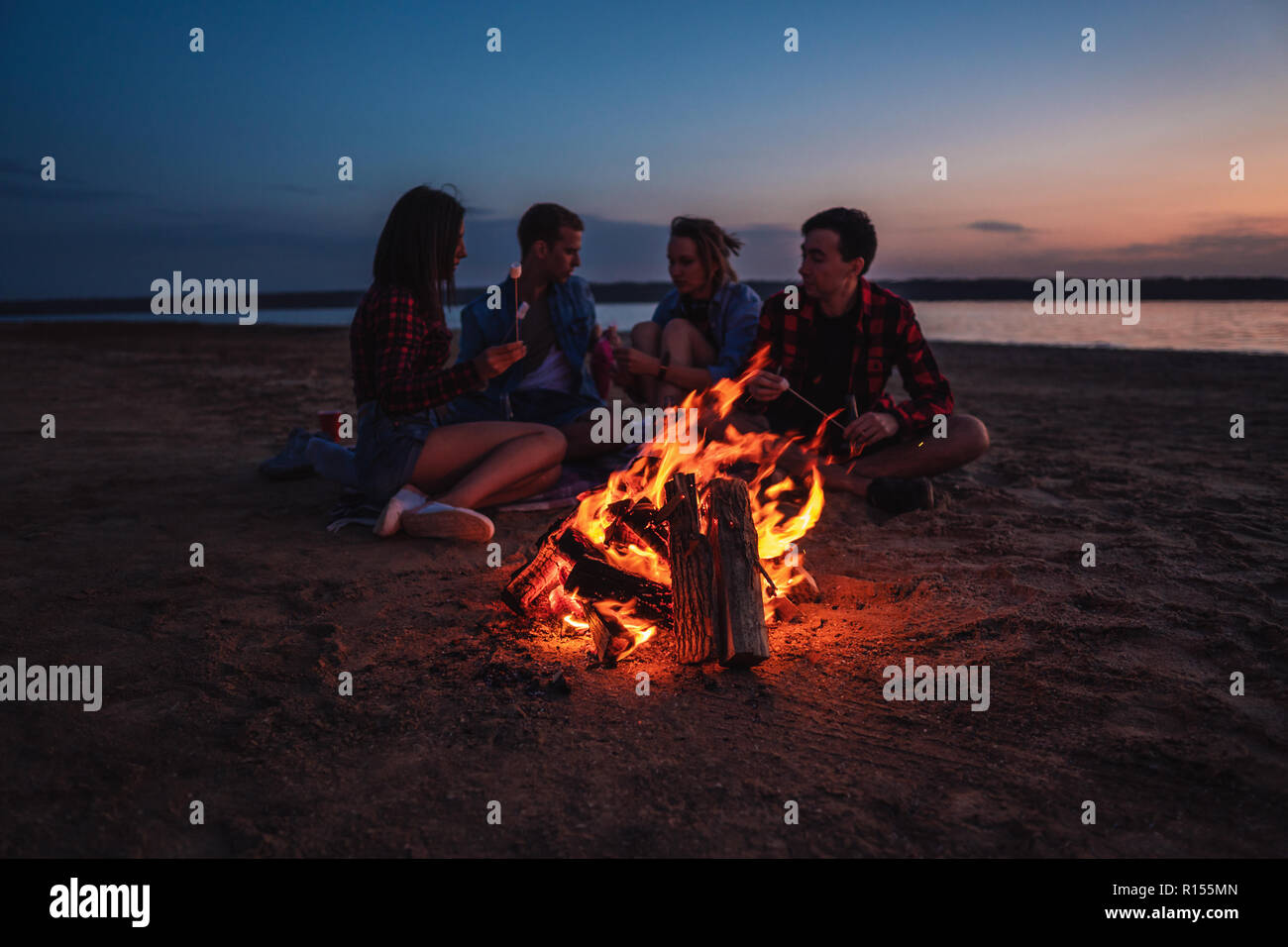 young friends have picnic with bonfire on the beach Stock Photo - Alamy