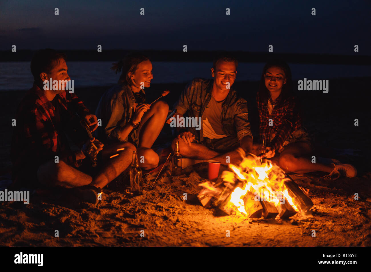 young friends have picnic with bonfire on the beach Stock Photo - Alamy