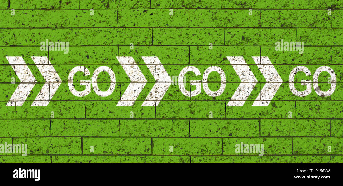 Go Go Go white word text and direction arrows on green stone brick wall ...