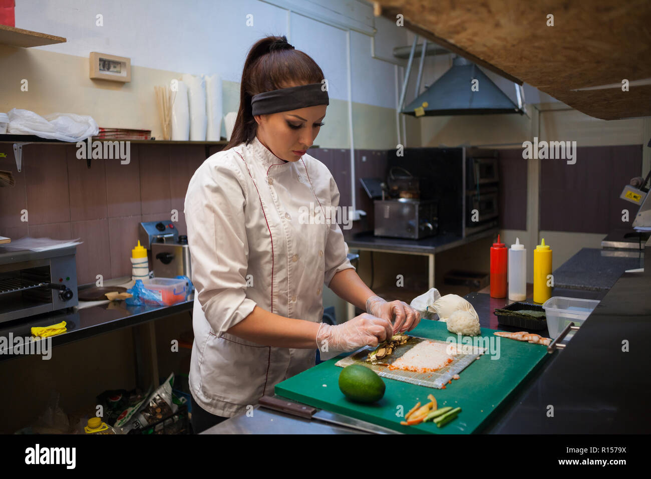 beautiful woman chef prepares sushi on restaurant kitchen Stock Photo ...