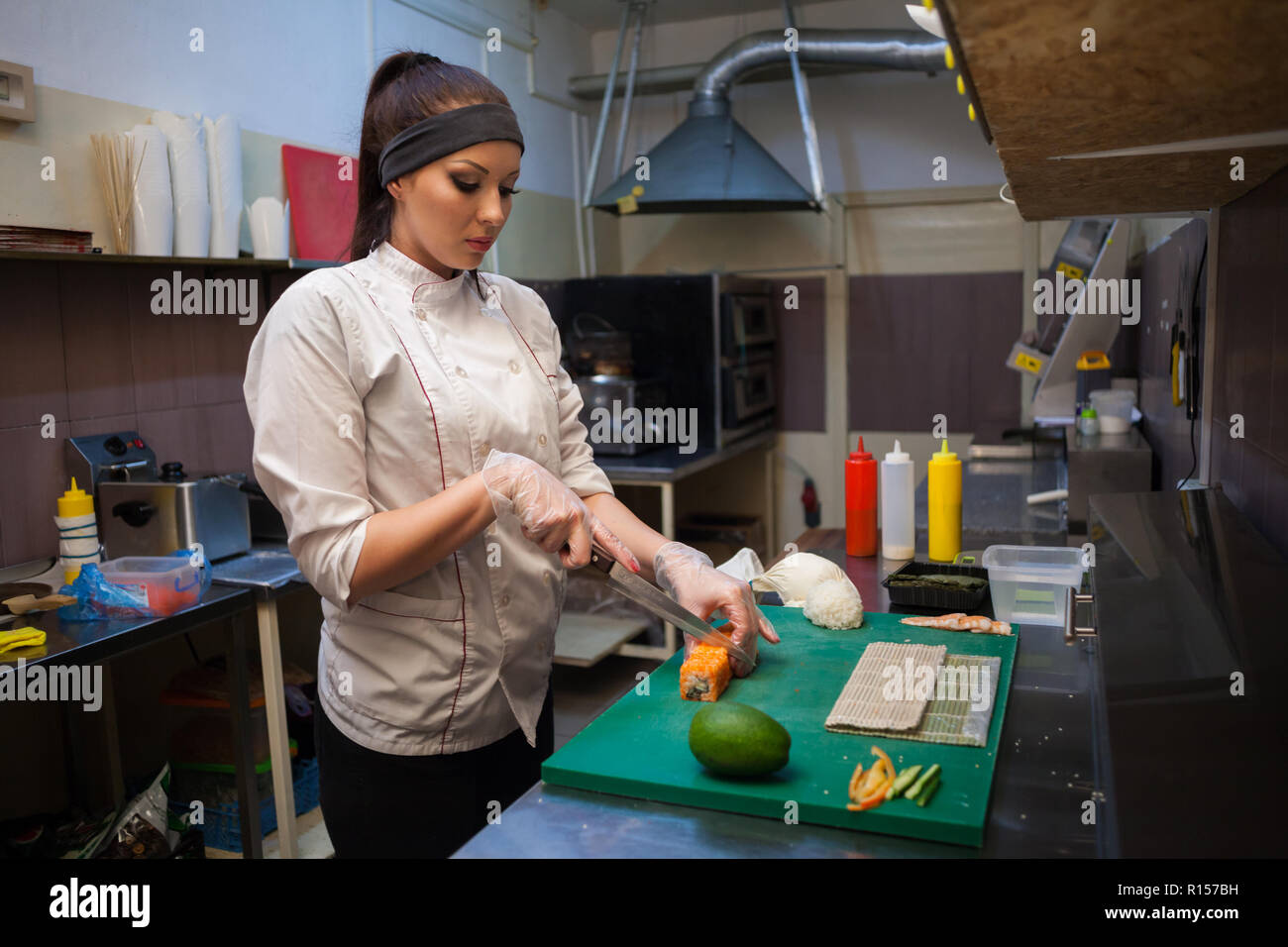 beautiful woman chef prepares sushi on restaurant kitchen Stock Photo ...