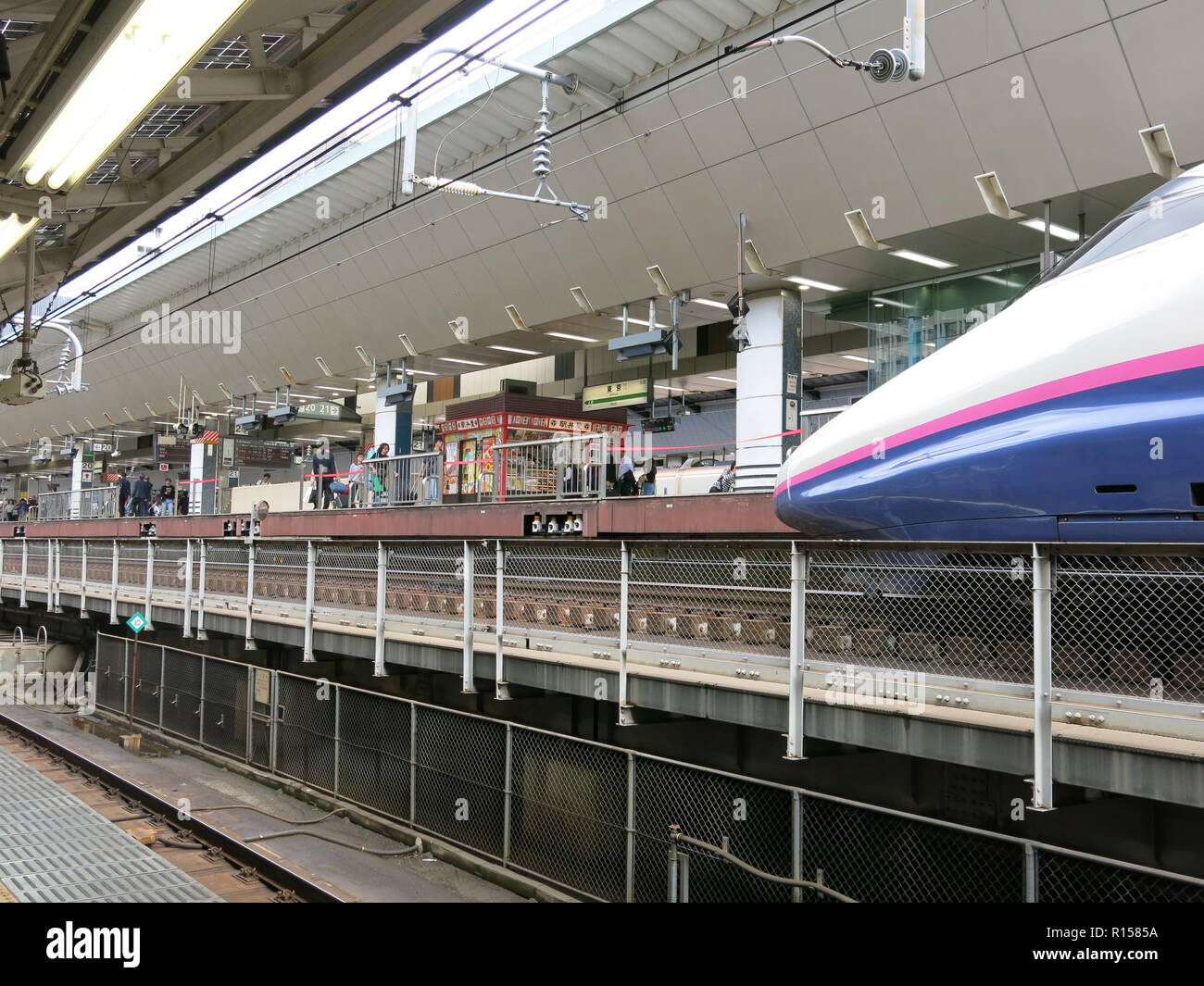 Front of a train pulls into view at a station on the Japanese JR rail ...