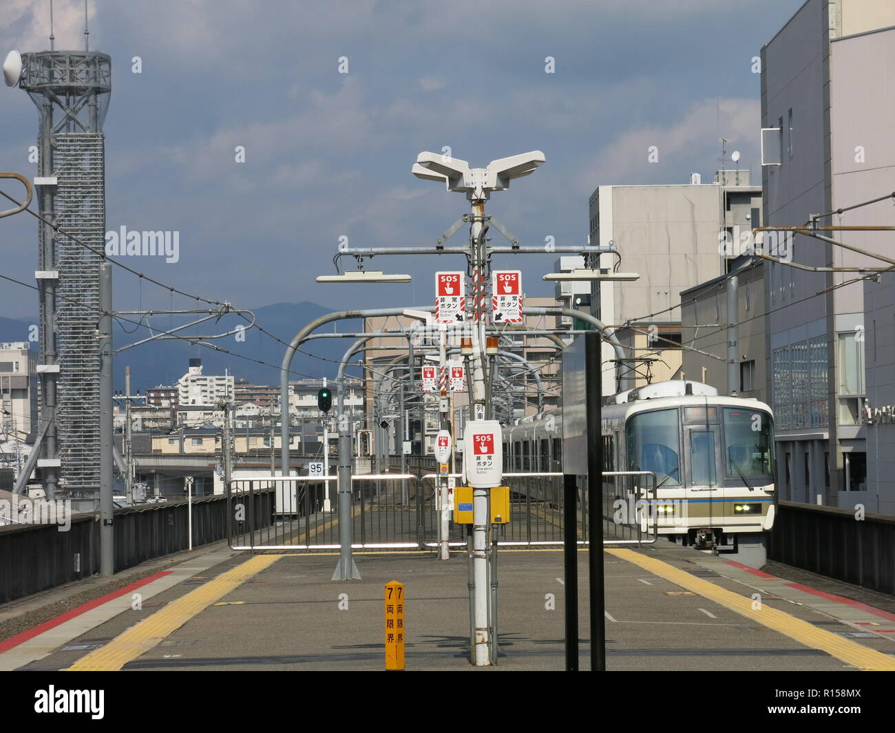 View of a suburban train arriving at the platform of a Kyoto train ...