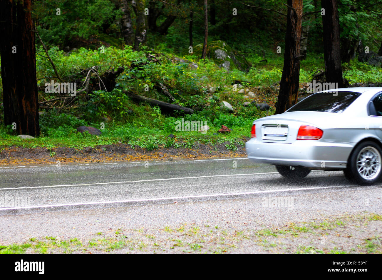 Automobile driving on the puddle on a highway Stock Photo - Alamy
