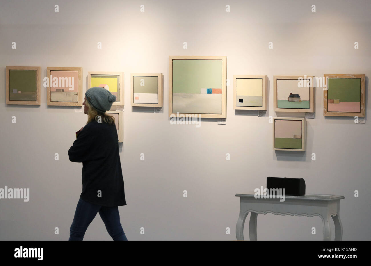 A woman passes work by artist Susan Buttner at the Art Source art show ...