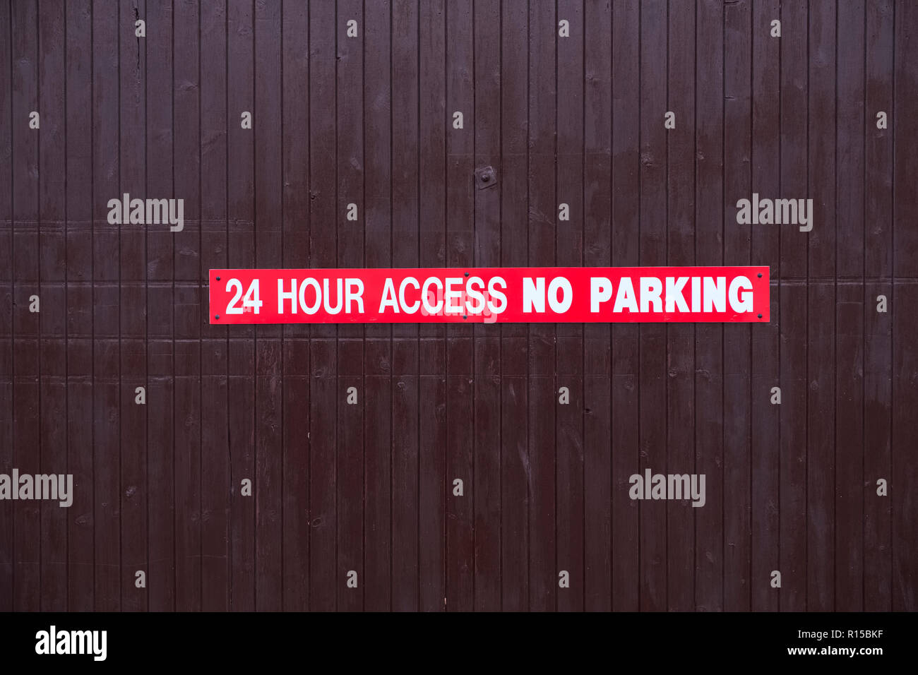 24 hour access no parking sign red and white on wooden access door ...