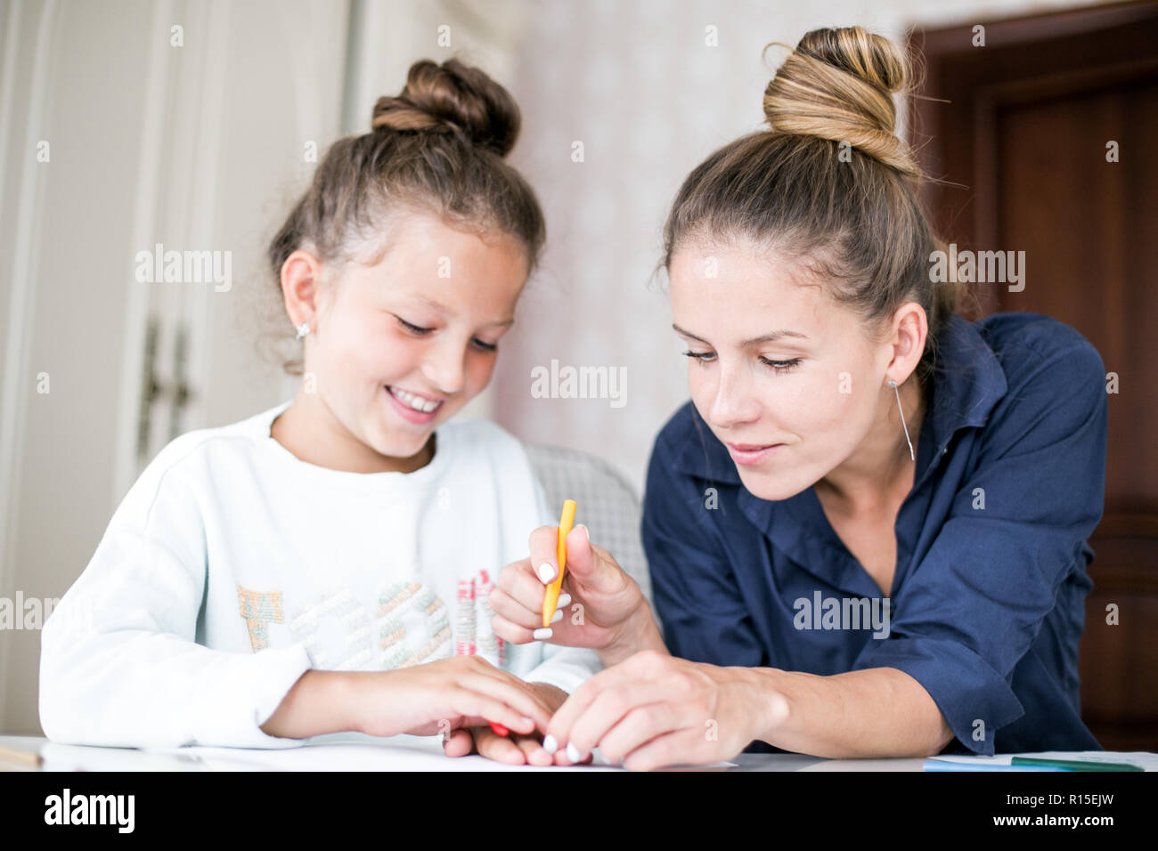 Happy family. Mother and daughter together paint and draw. Adult woman ...