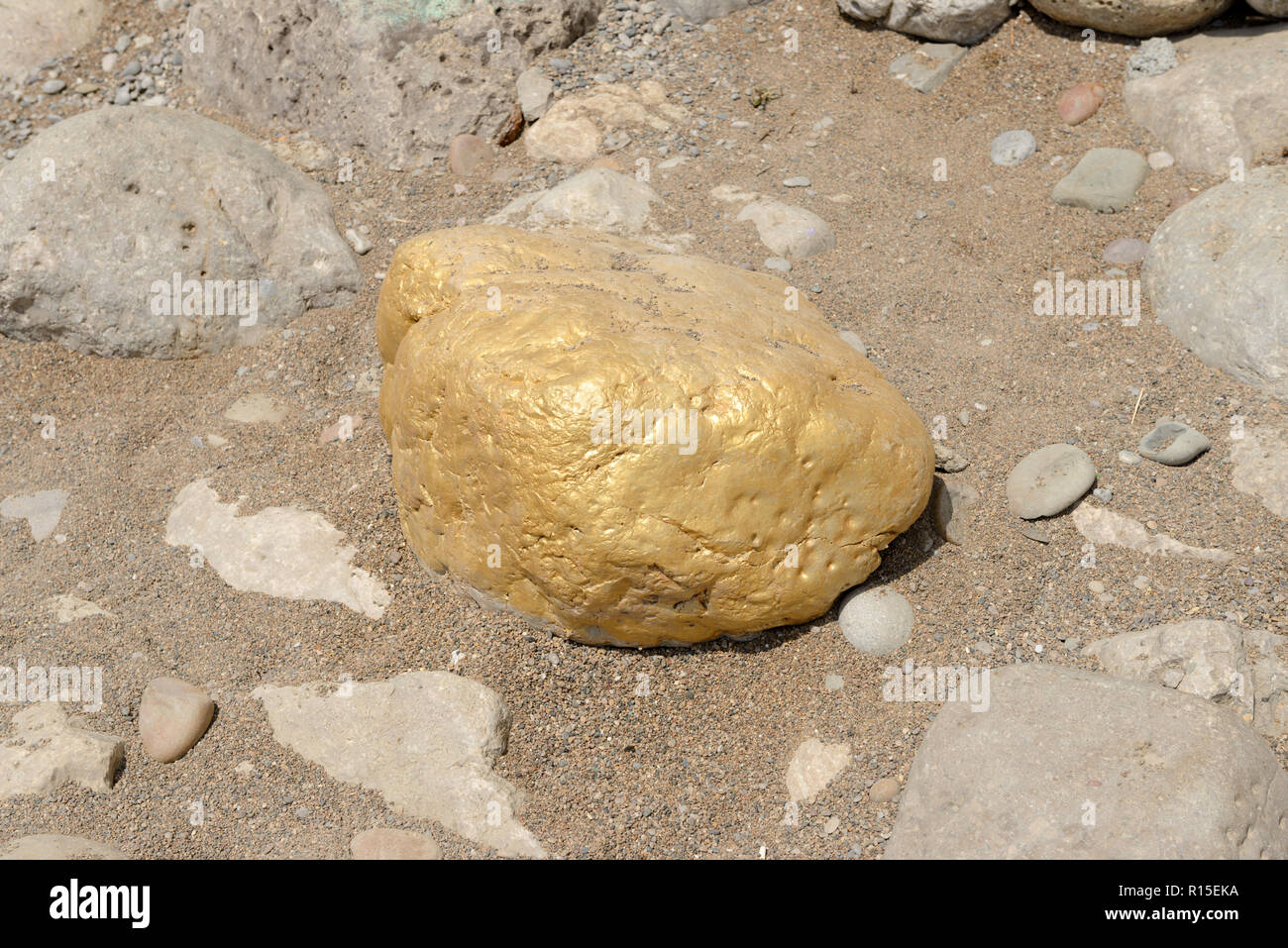 Close-up stone that painted in golden color in bright sunlight on ...