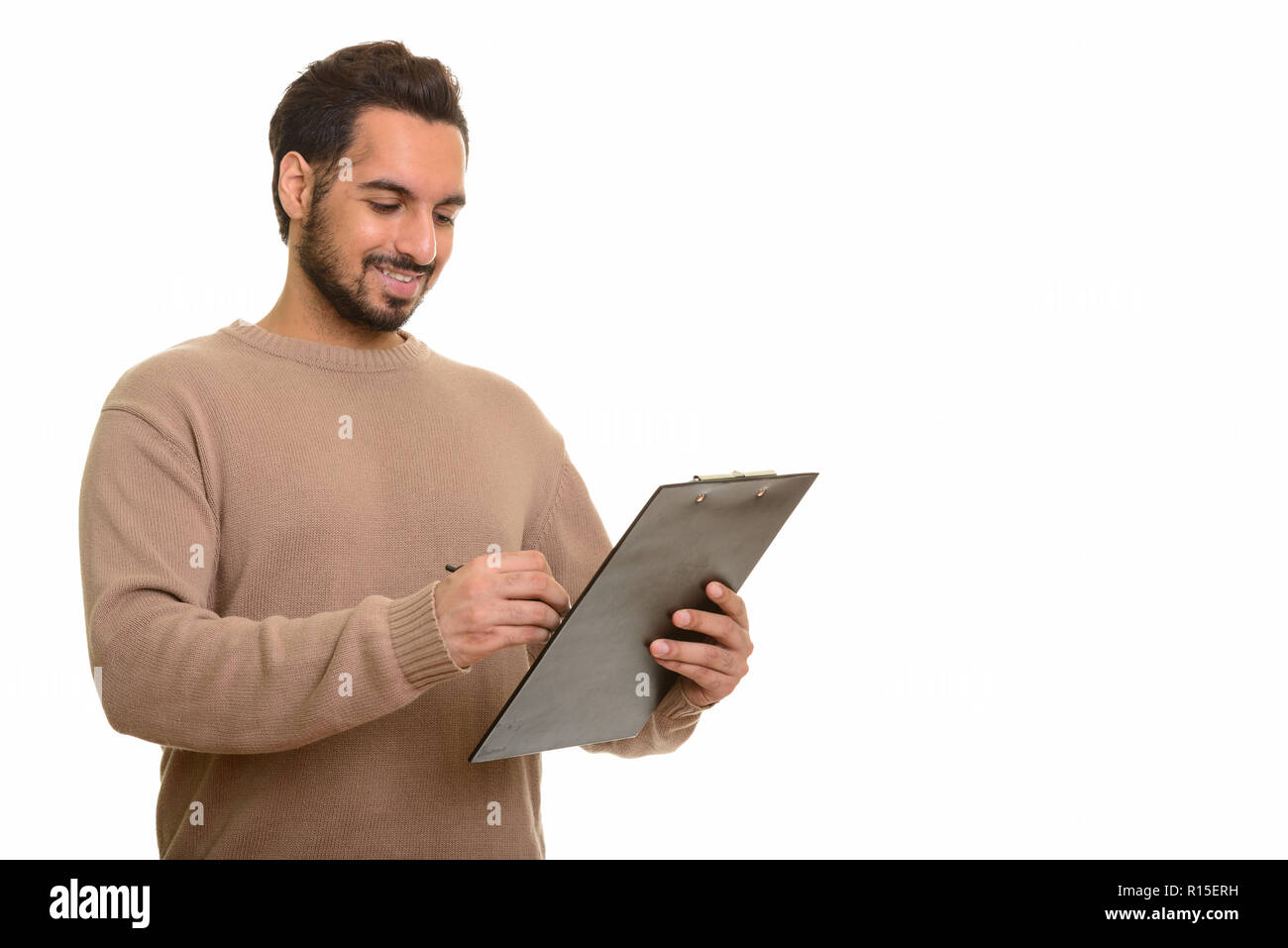 Young happy Indian man writing report on clipboard Stock Photo - Alamy